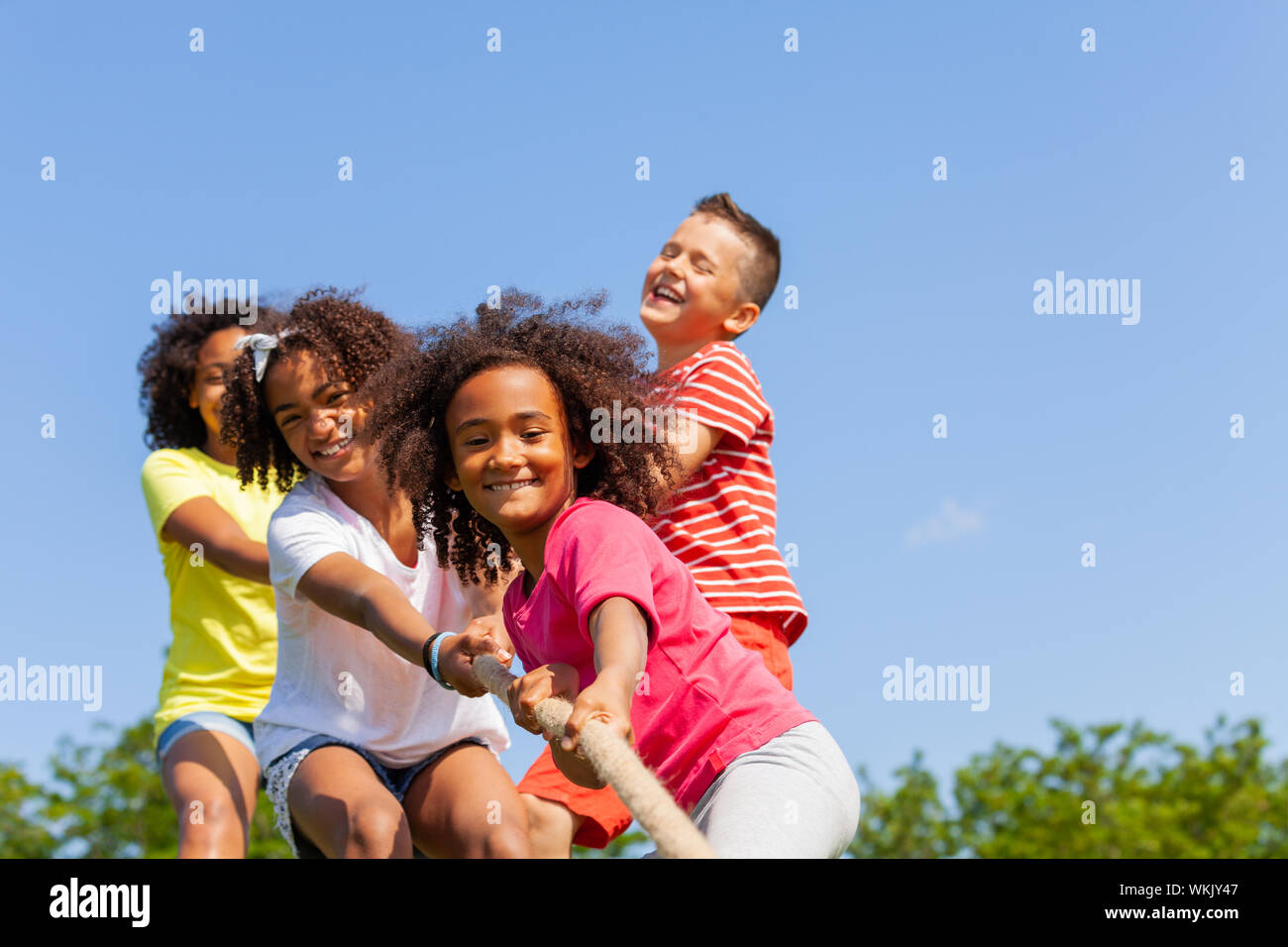 Boys and girls play pull cord in competitive game Stock Photo - Alamy