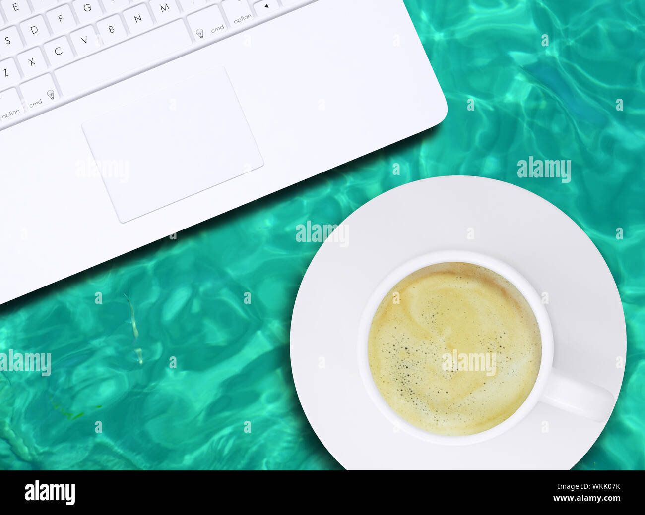 Laptop and coffee cup on water surface. Computer technology concept ...
