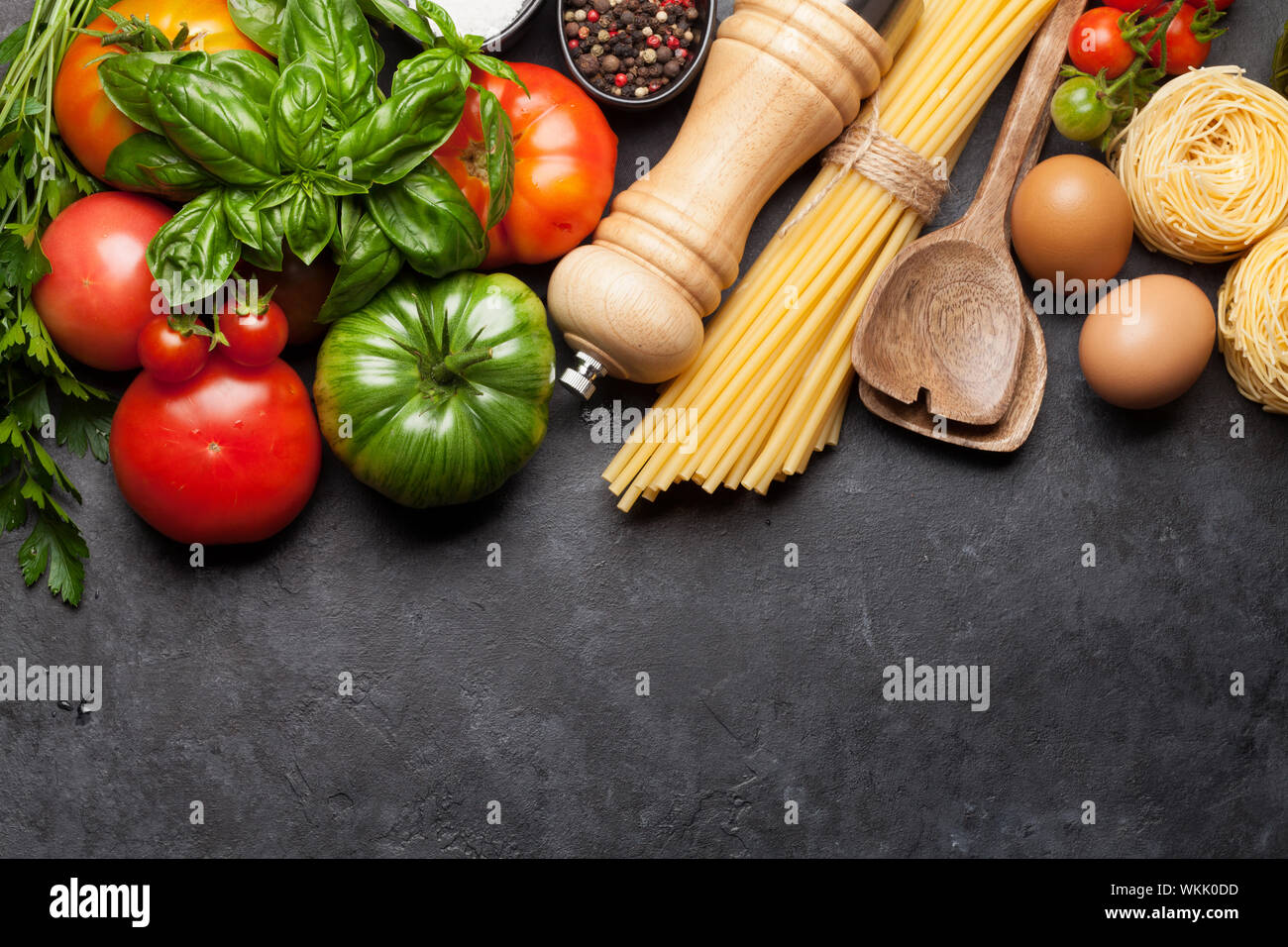 Pasta, tomatoes and herbs. Cooking ingredients on stone table. Top view ...