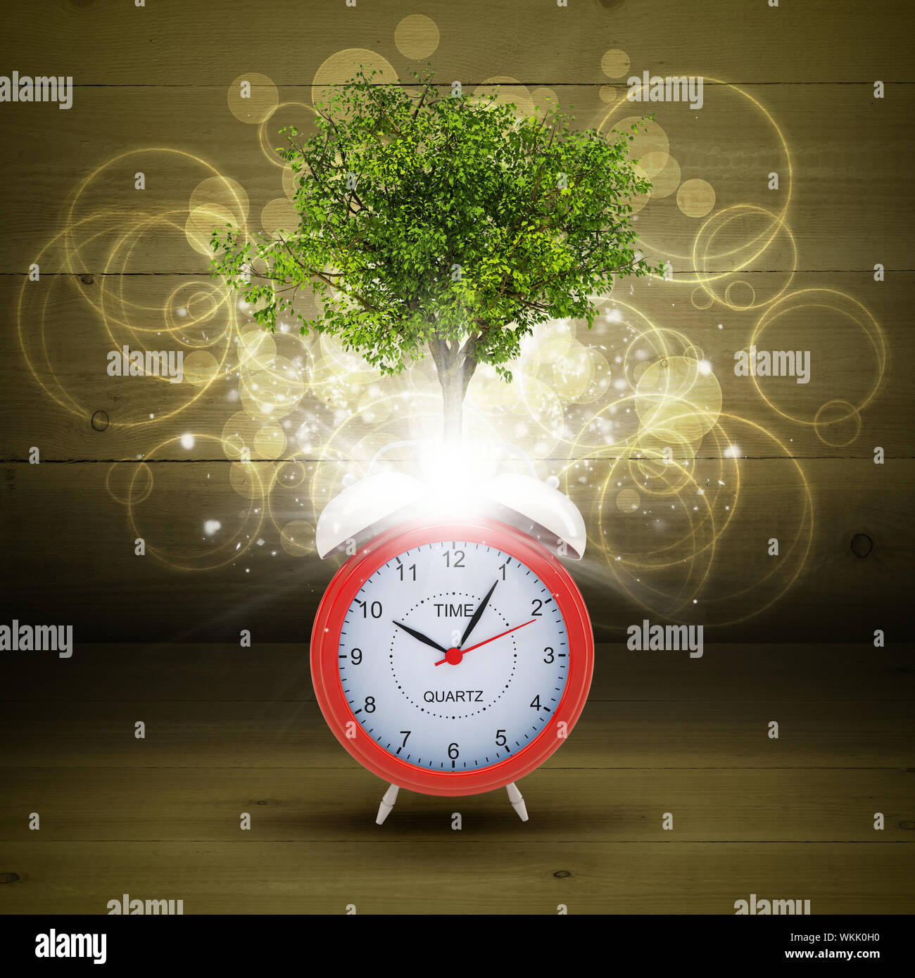 Alarm clock with magical green tree and rays of light on dark ...