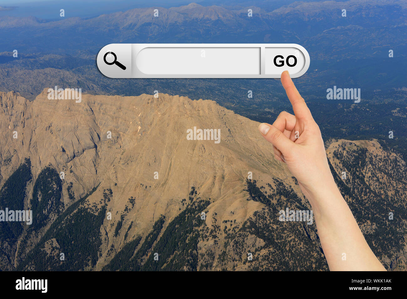Human hand indicates the search bar in browser. Mountain and sky on ...
