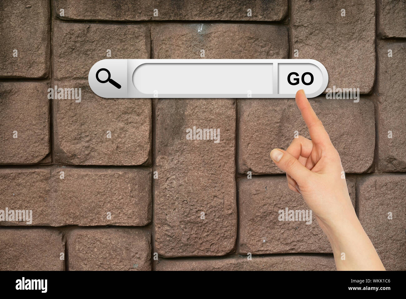Human hand indicates the search bar in browser. Wall of brown bricks on ...