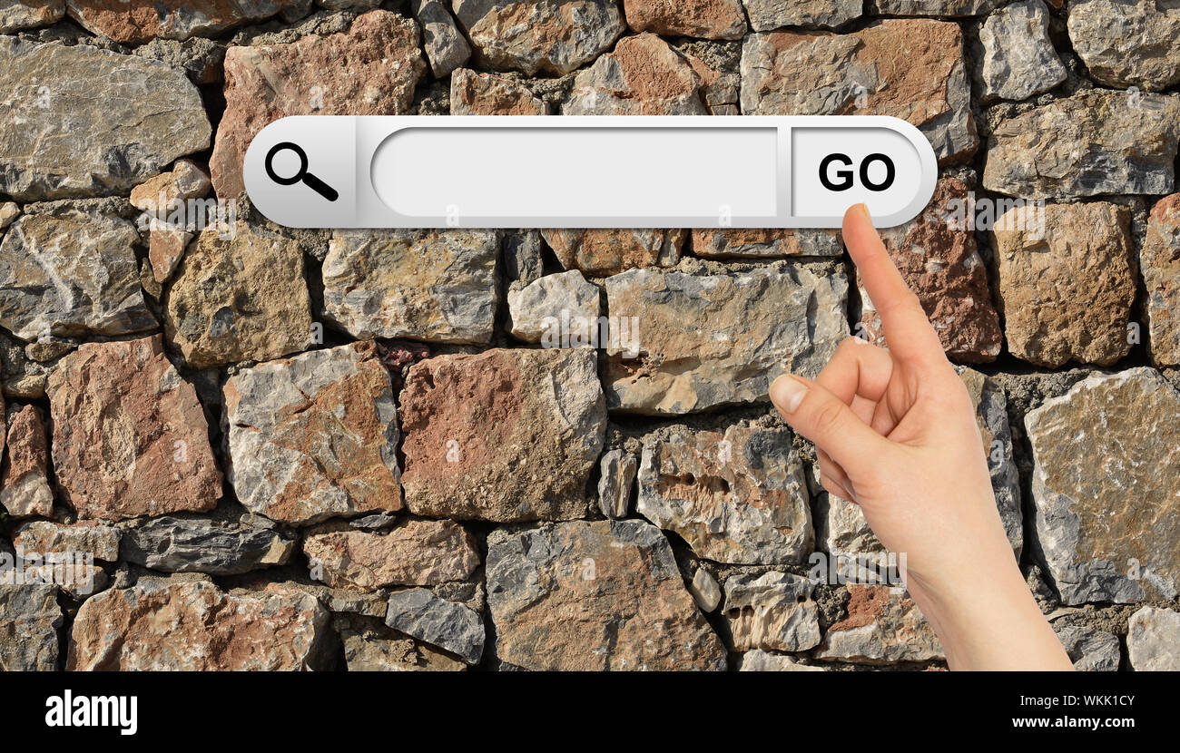 Human hand indicates the search bar in browser. Wall of natural bricks ...