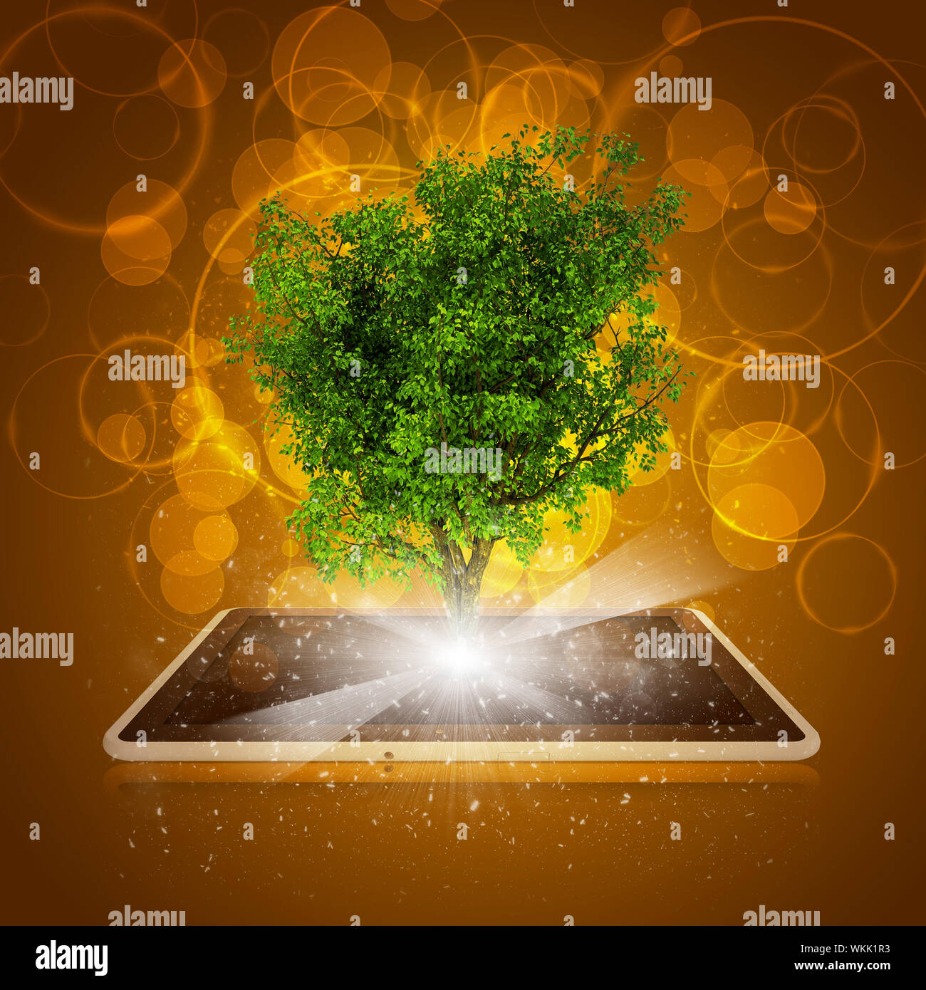 Tablet pc with magical green tree and rays of light on dark background ...