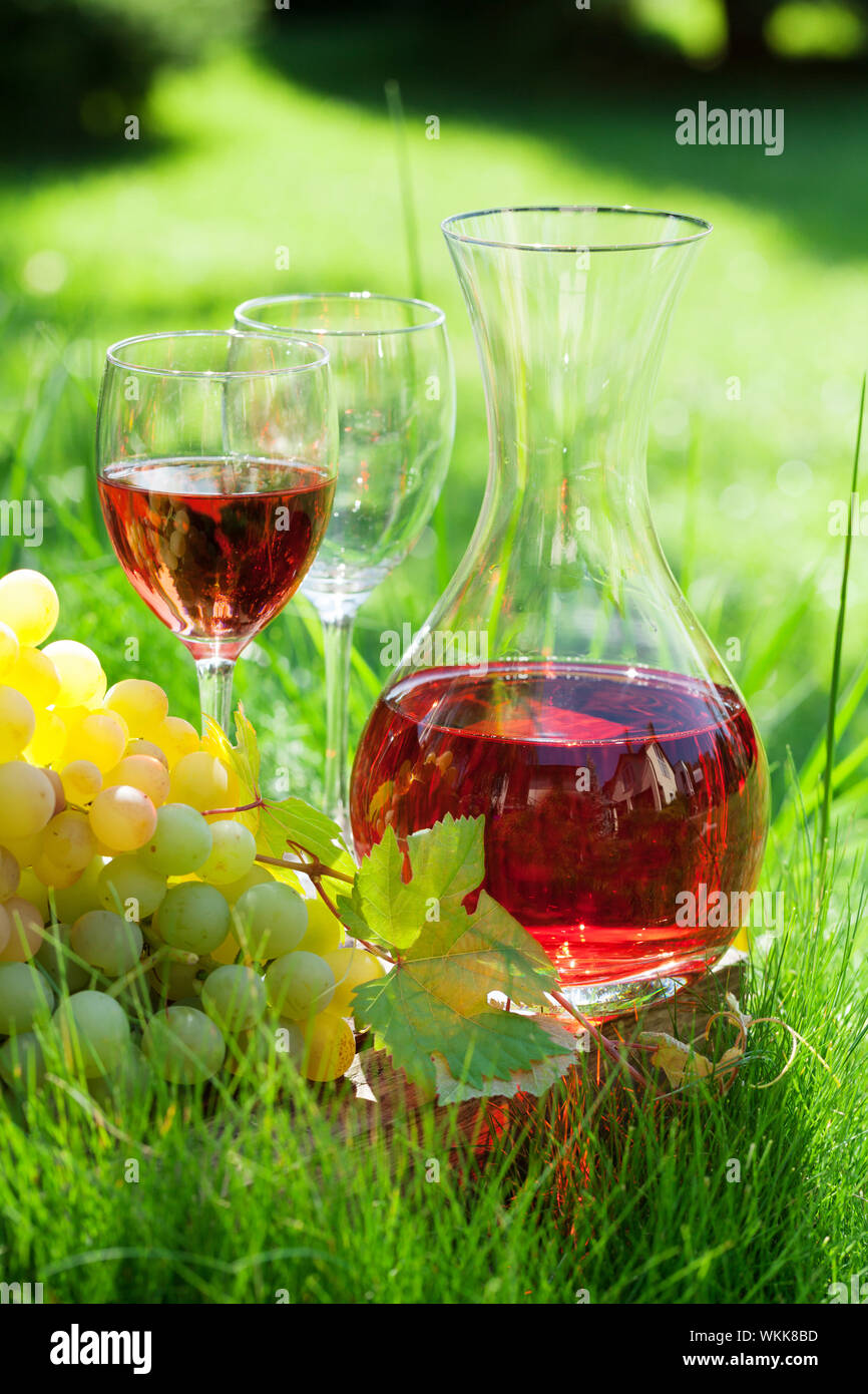 Rose wine in decanter and grapes. Outdoor in the vineyard Stock Photo ...