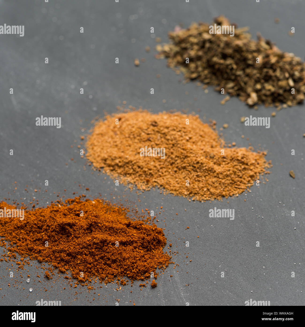 Three different colorful powder spices small piles on black chalkboard ...