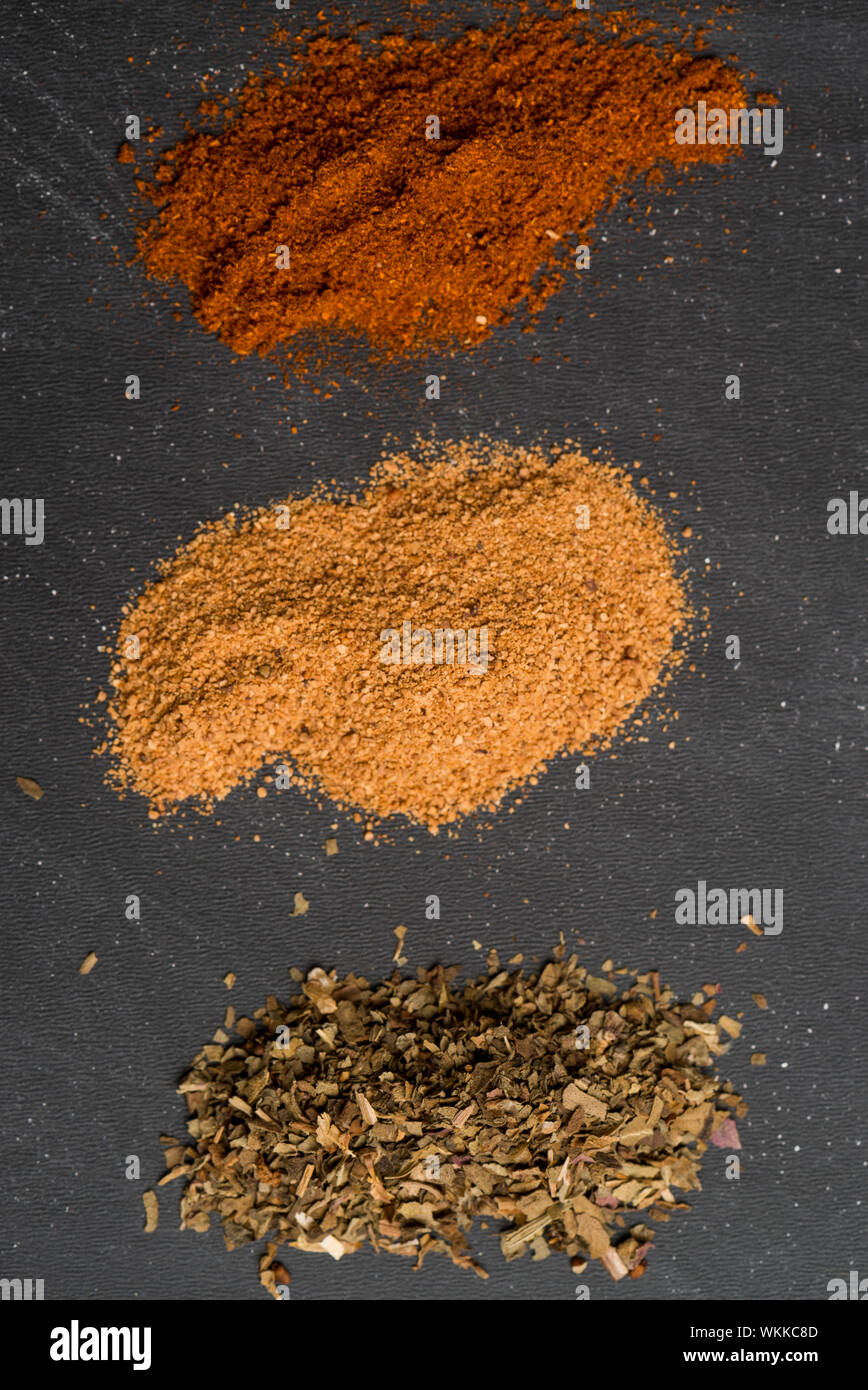 Three different colorful powder spices small piles on black chalkboard ...