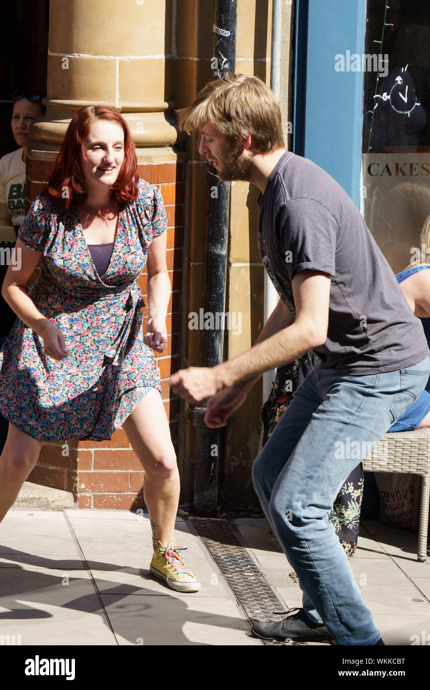 A man and women dancing Lindy Hop in the street at Fossgate Festival ...