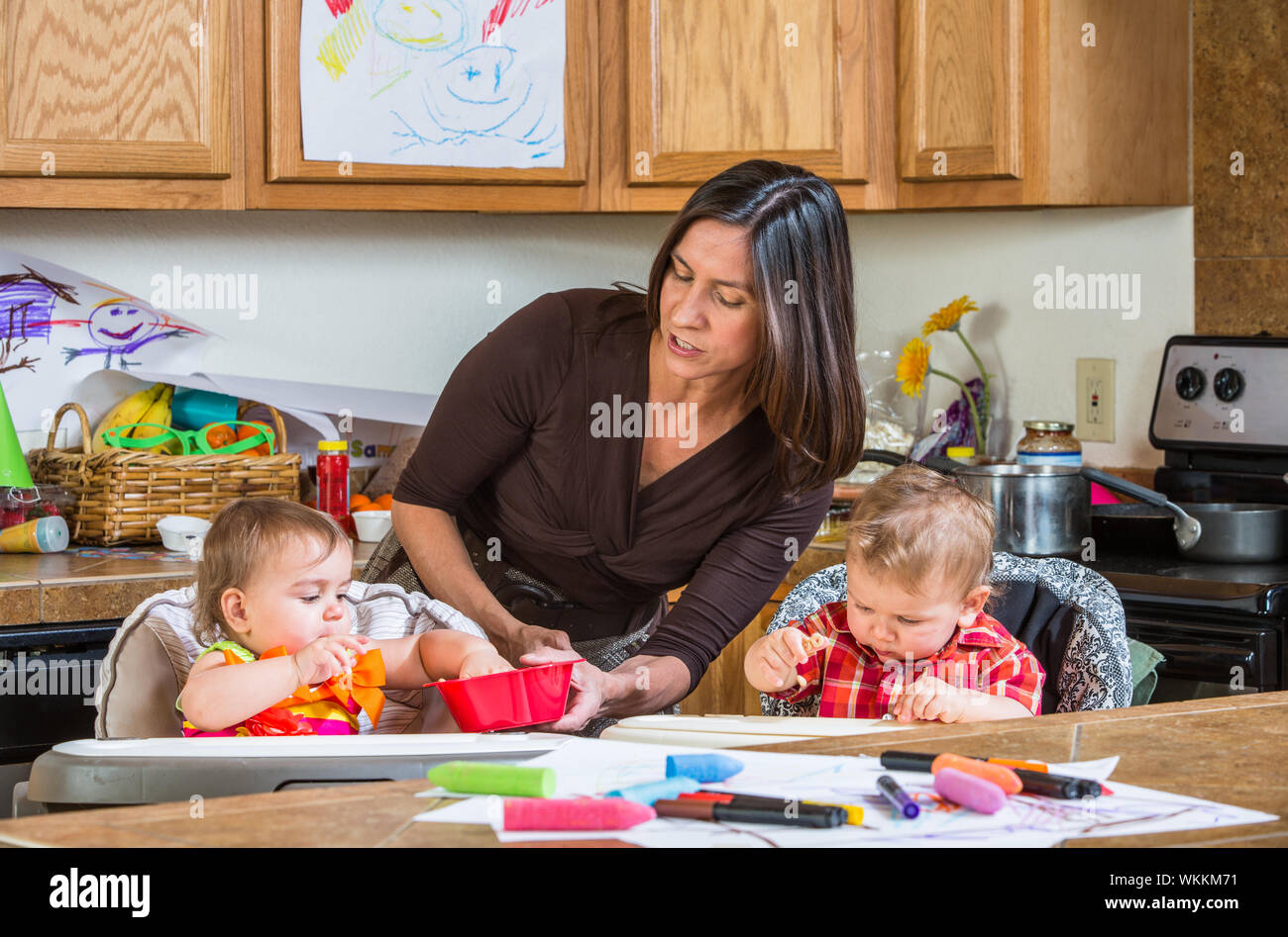 A mother in the kitchen feeds babies breakfast Stock Photo - Alamy