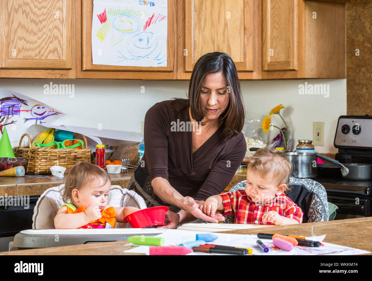 A mother in the kitchen feeds babies breakfast Stock Photo - Alamy