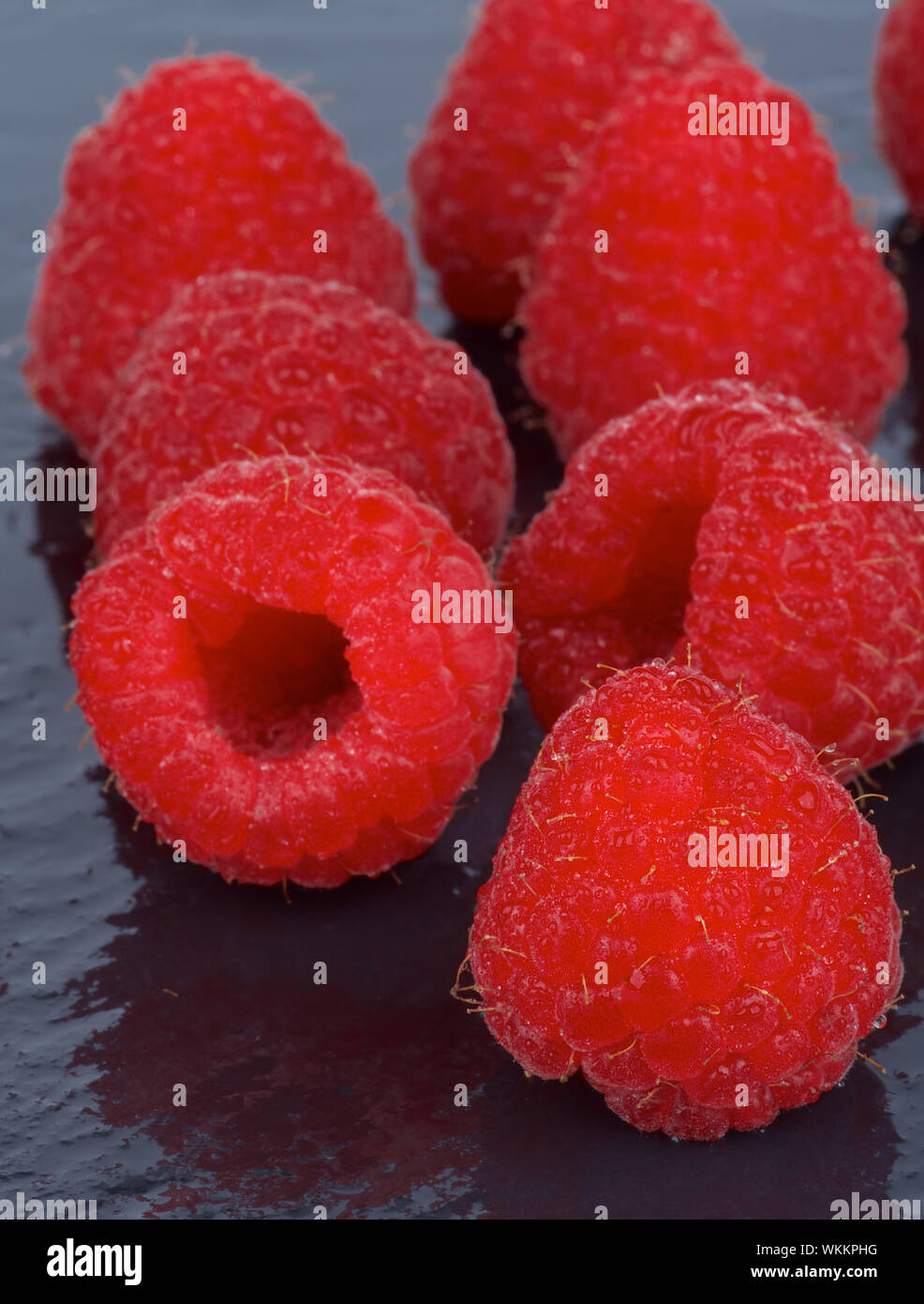 Fresh Sweet Raspberries with Water Drops closeup on Black Wet background Stock Photo - Alamy