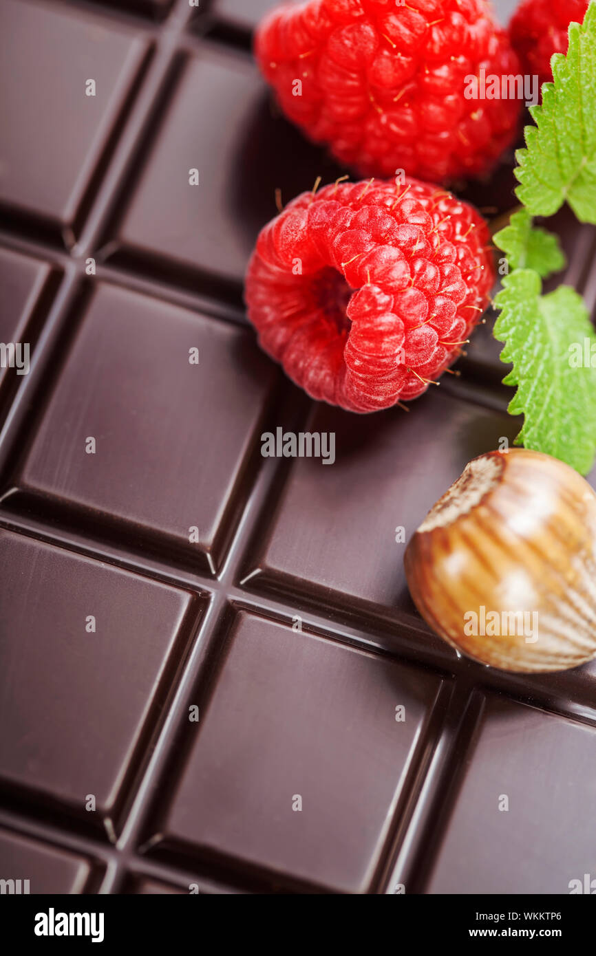 dark chocolate bar with raspberry as background Stock Photo - Alamy
