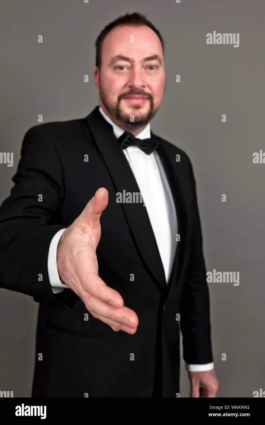 A handsome man with a goatee beard giving hand Stock Photo - Alamy