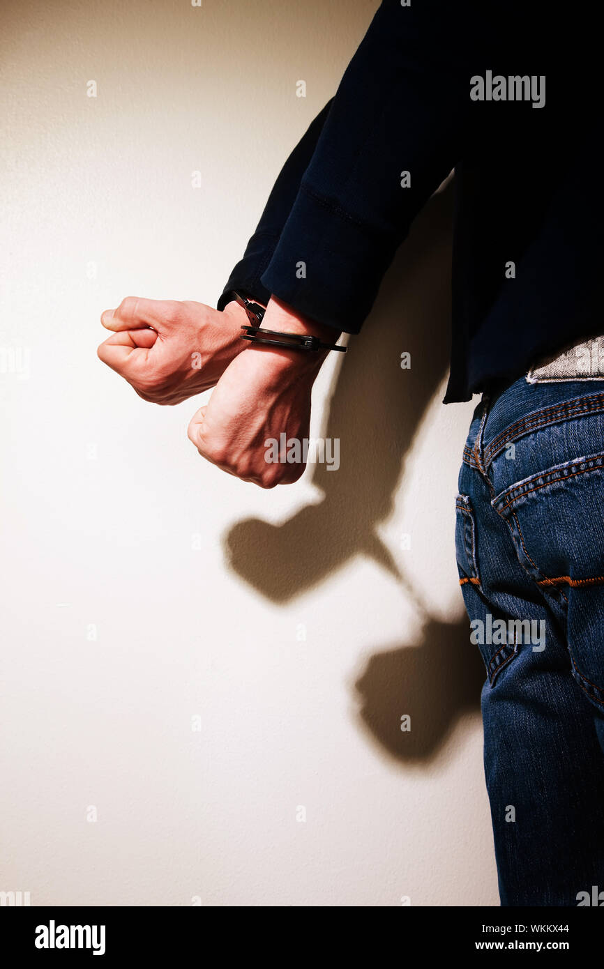 Young man with hands cuffed behind his back Stock Photo - Alamy