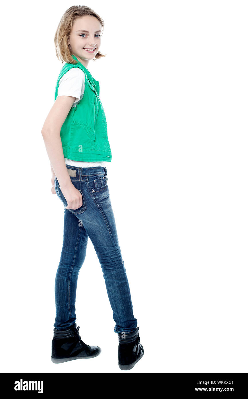 Smiling young girl turning back, hands in pocket Stock Photo - Alamy