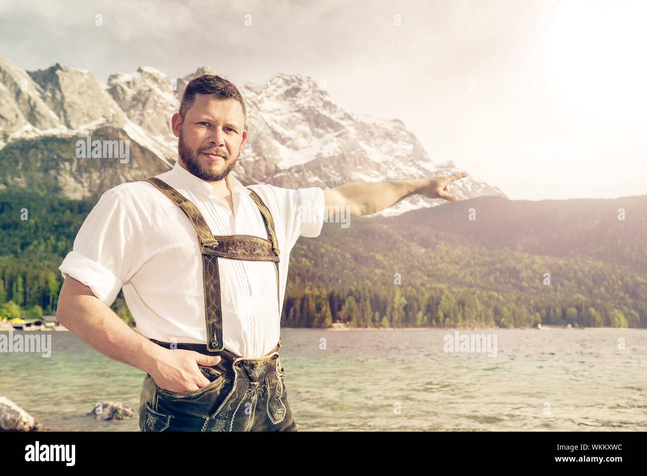 A traditional bavarian man at lake Eibsee with the Zugspitze mountain ...