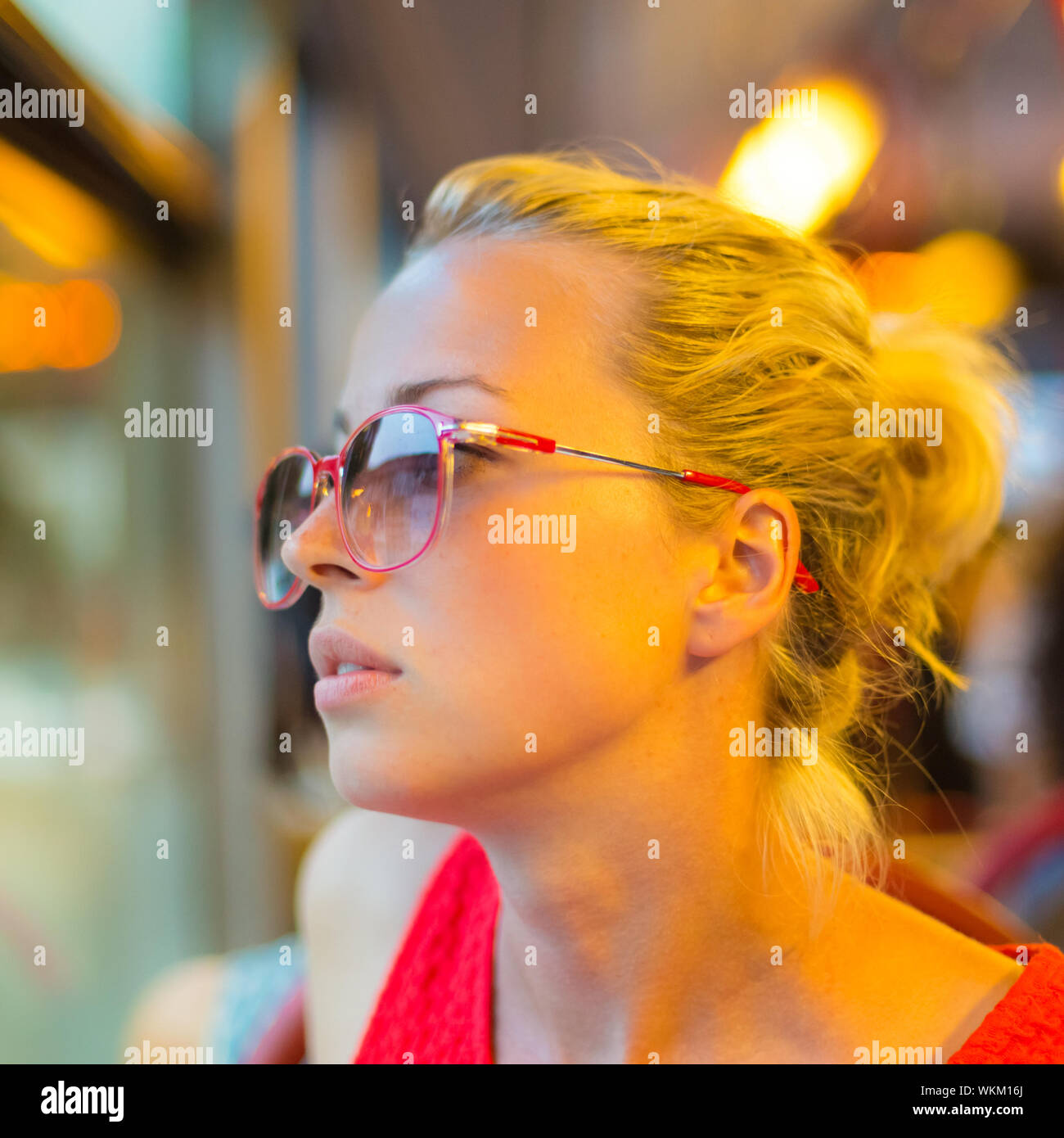 Thoughtful lady riding on a tram and looking out the window Stock Photo ...
