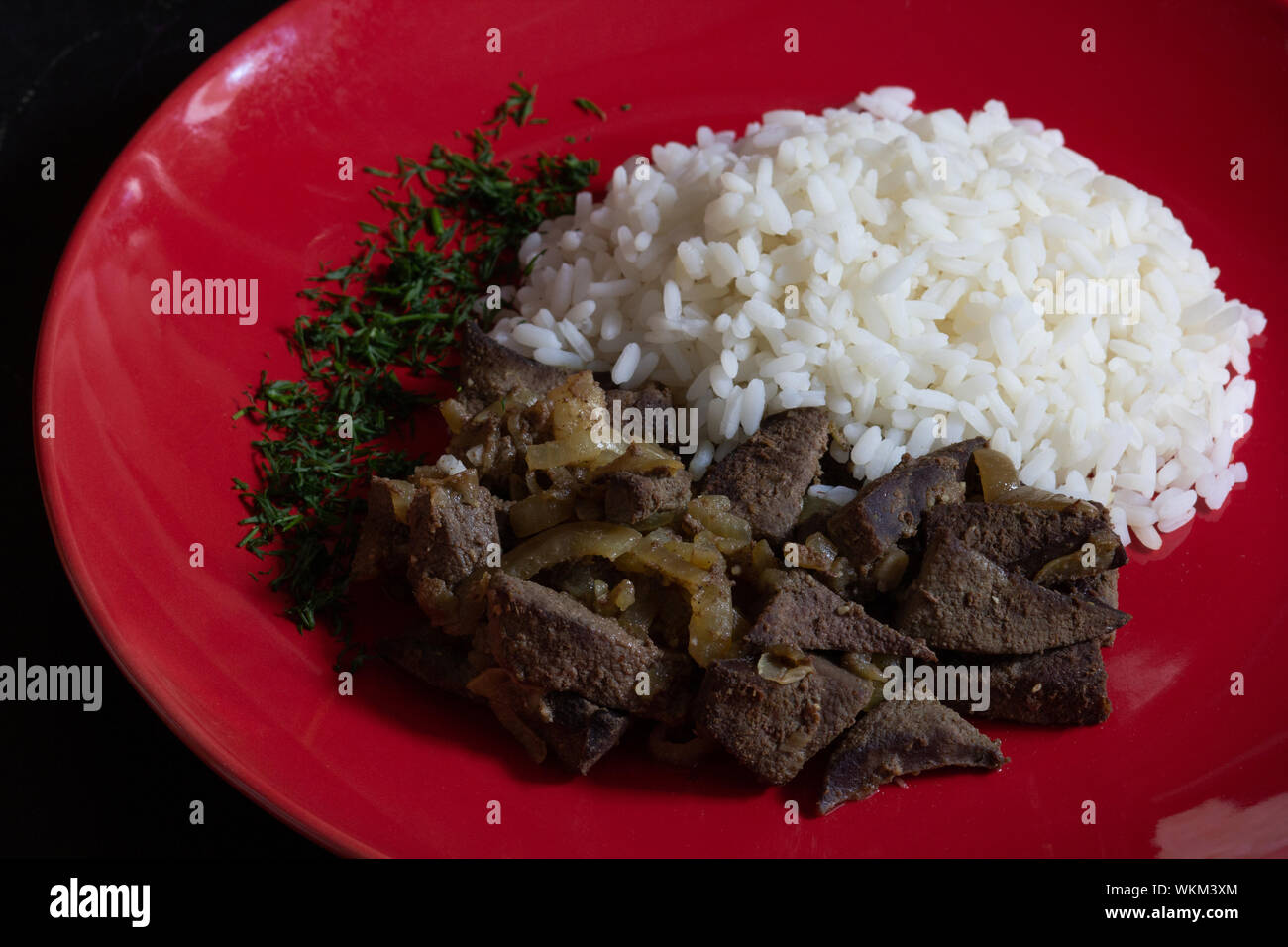 Cooked liver and rice on red plate on the black background Stock Photo ...