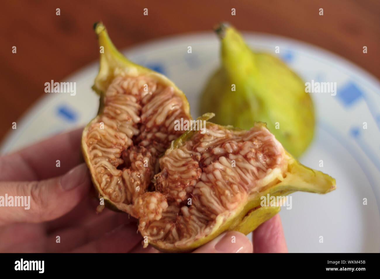 Hand holding a fresh cut fig Stock Photo - Alamy