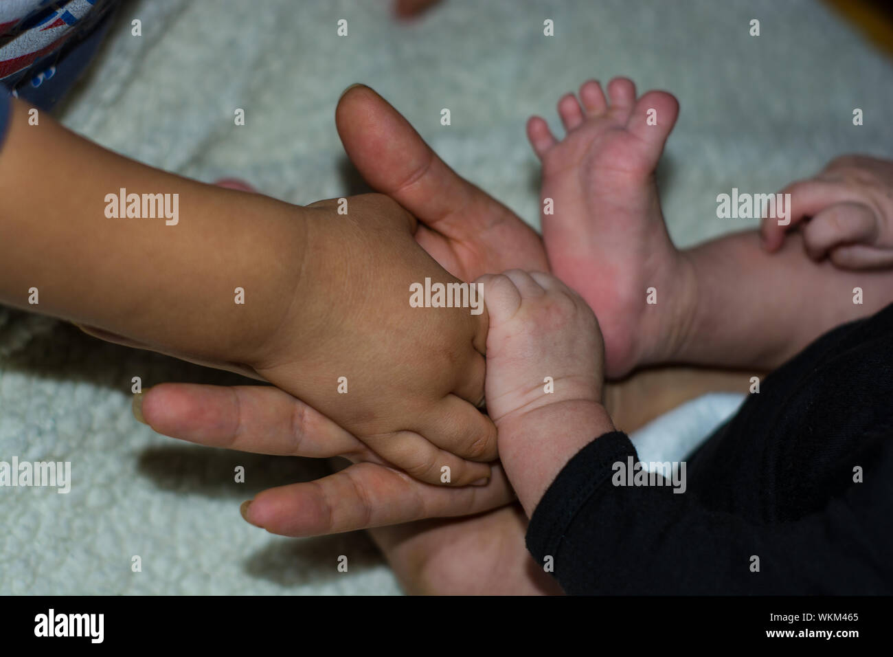 newborn baby playing with his hands and feet Stock Photo - Alamy