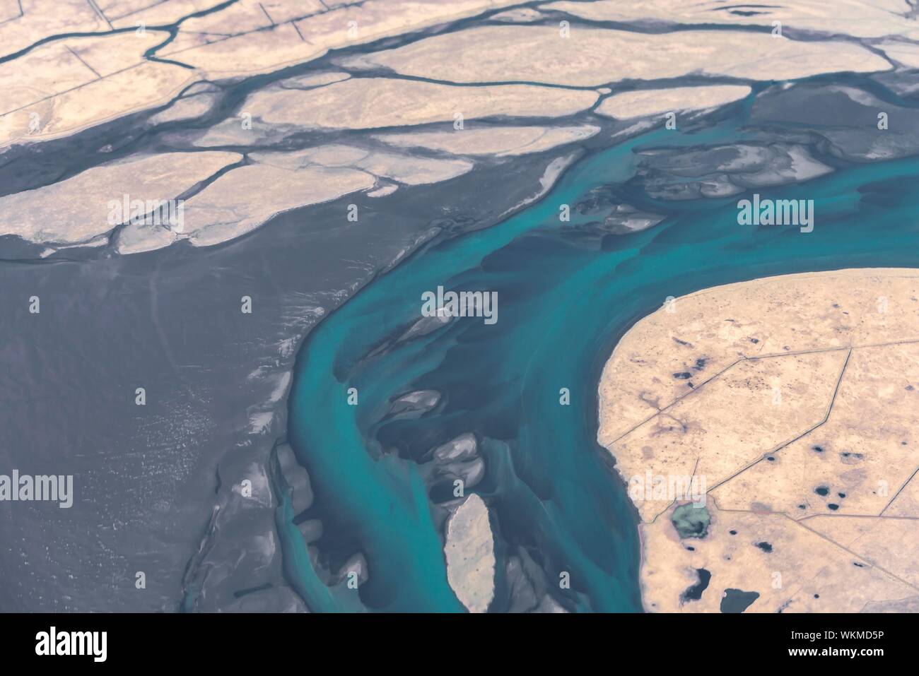 View from the plane to a wide riverbed with turquoise river, bird's eye ...