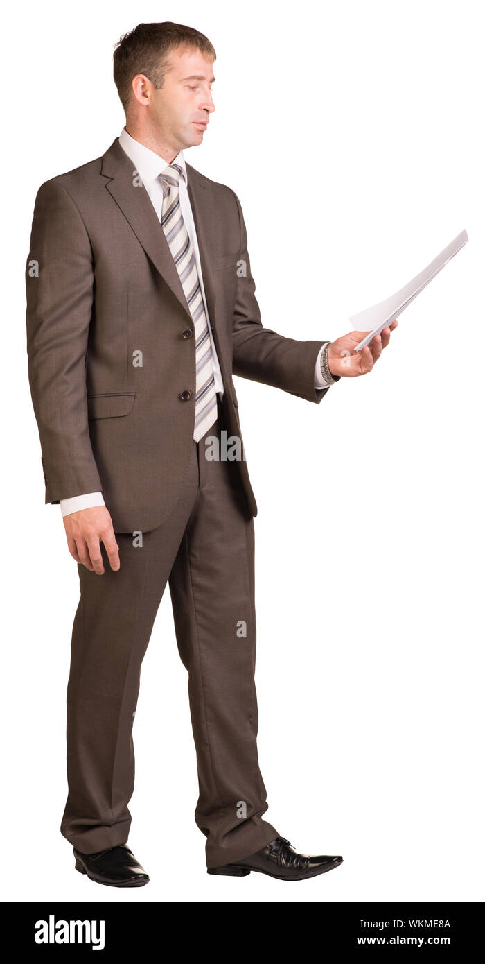 Standing businessman looking at paper sheet. Isolated on the white ...
