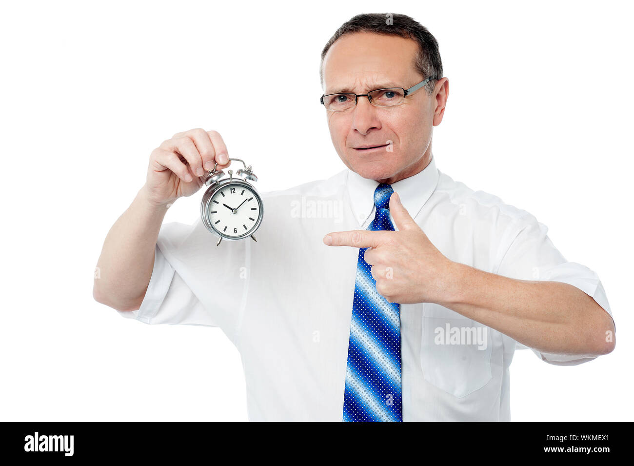 Mature business executive pointing at clock Stock Photo - Alamy