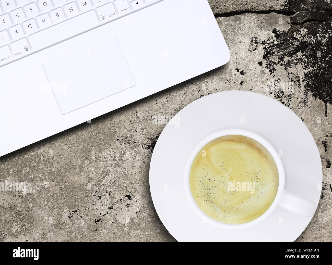 Laptop and coffee cup on old concrete surface. Computer technology ...