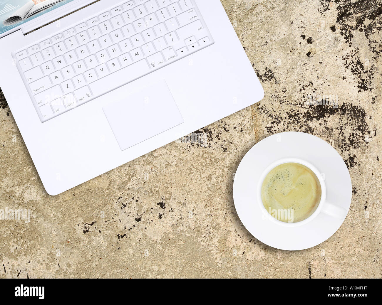 Laptop and coffee cup on old concrete surface. Computer technology ...