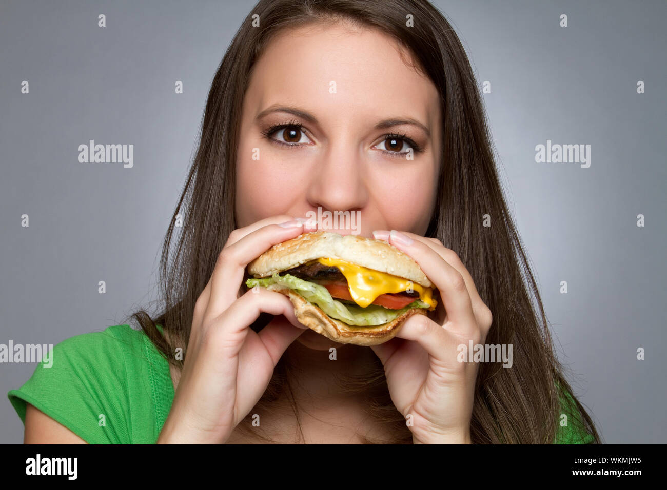 Beautiful girl eating hamburger food Stock Photo - Alamy