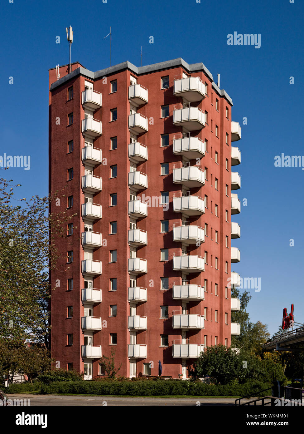 A light red apartment complex against a blue sky Stock Photo - Alamy