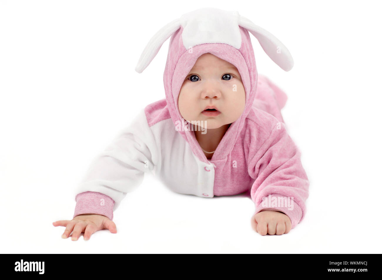 Portrait of four month baby lying on the floor wearing bunny suit ...