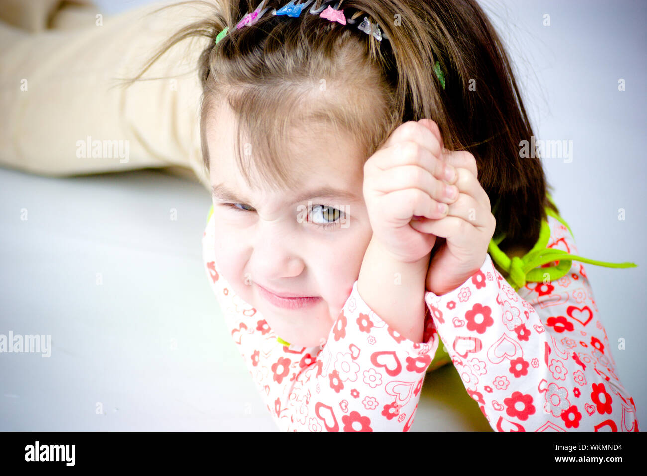 Funny girl lying on floor aiming at you Stock Photo - Alamy