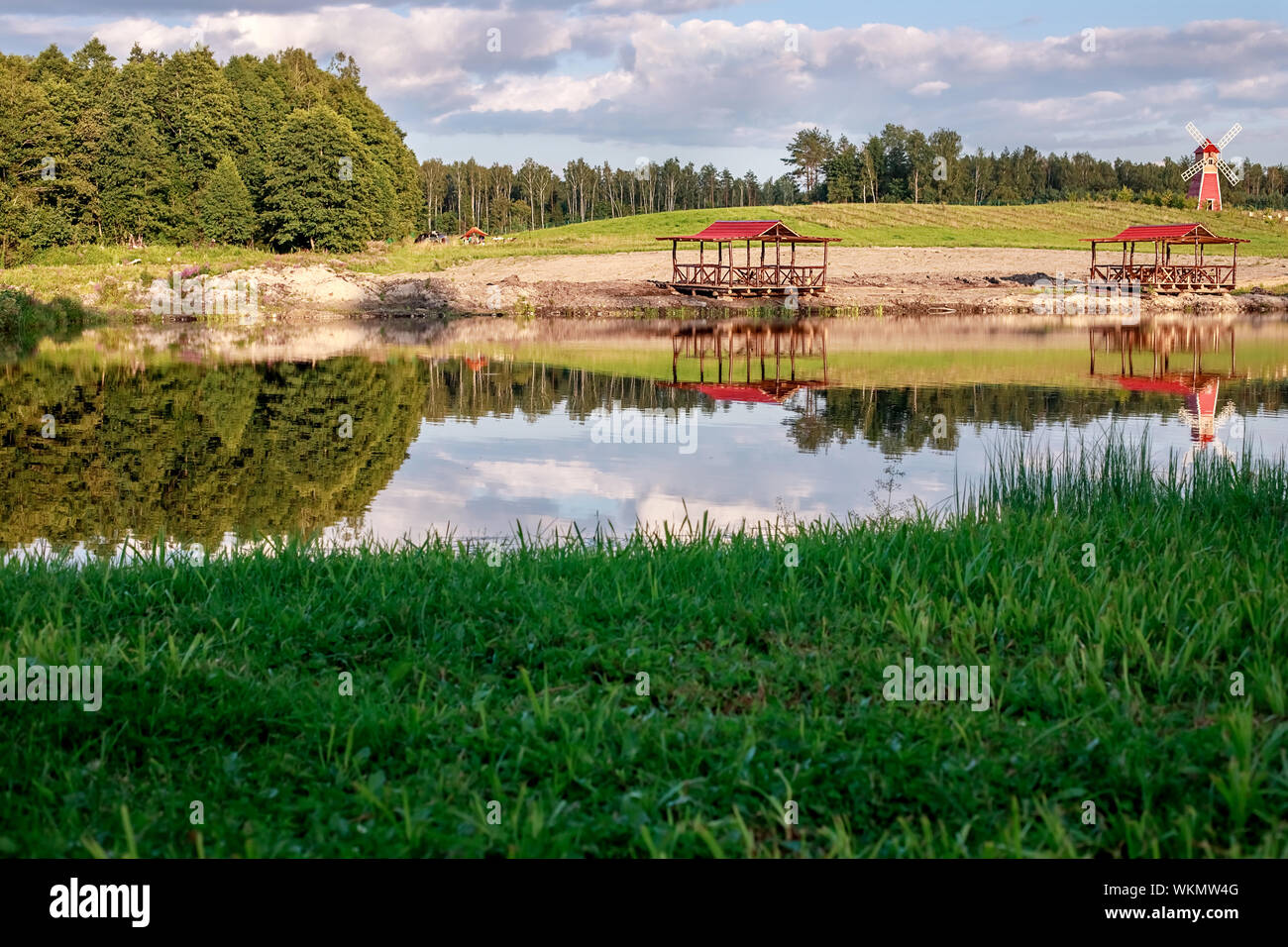 Rest zone. Blue water in a forest lake with pine trees. The forest is ...