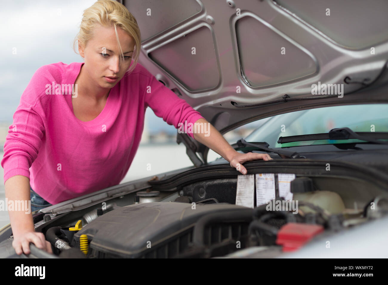 Woman inspecting broken car engine Stock Photo - Alamy