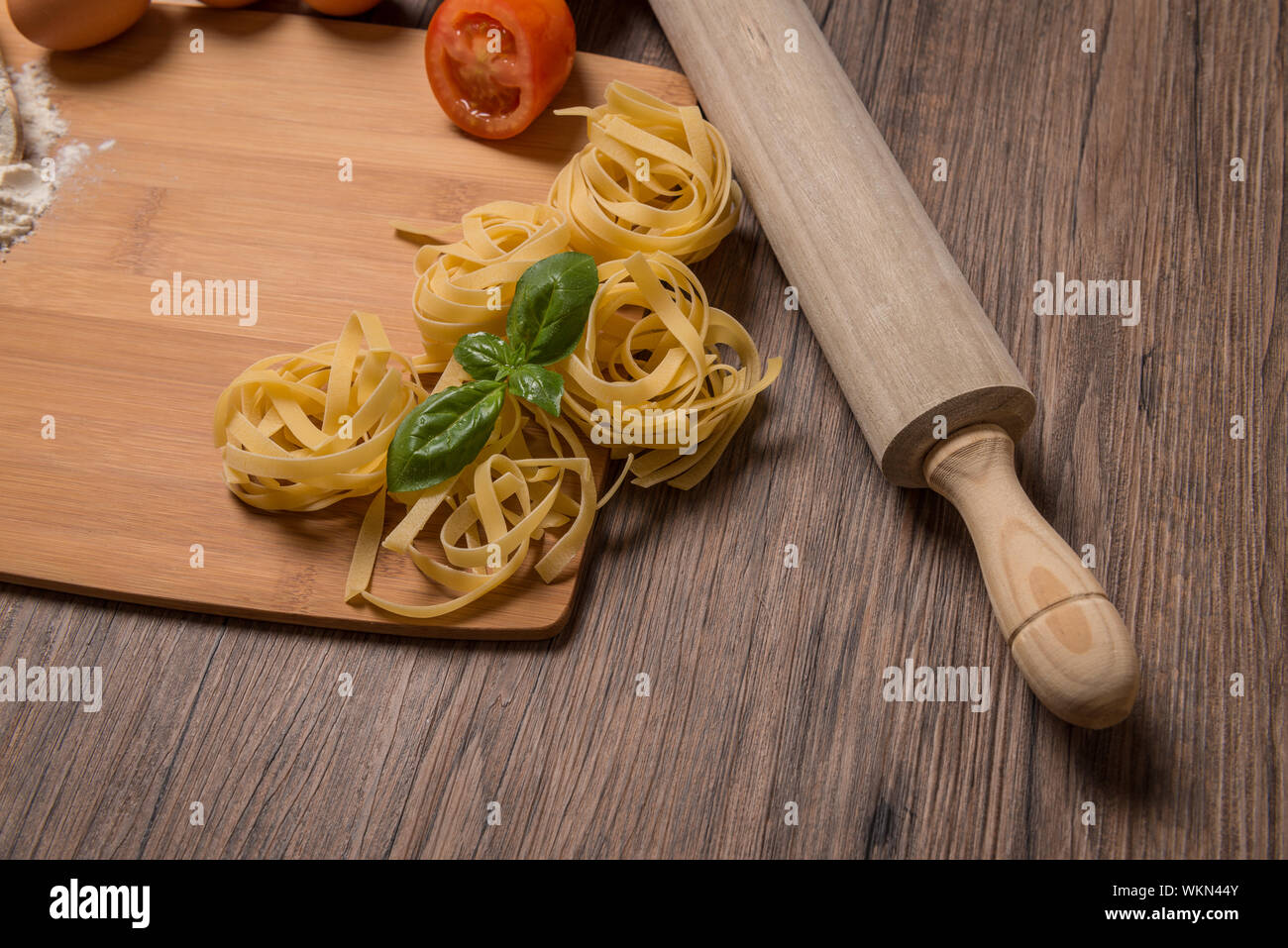 Uncooked italian pasta, brown wood table background Stock Photo - Alamy