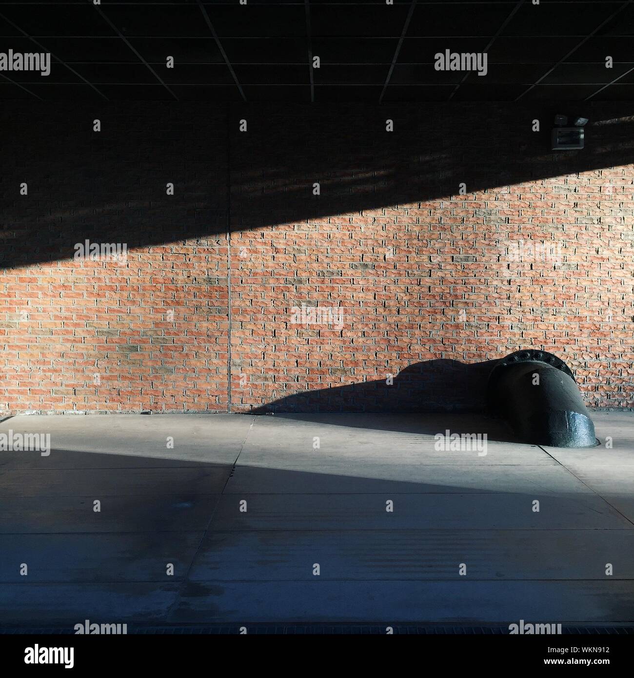 Pipe On Brick Wall Stock Photo - Alamy