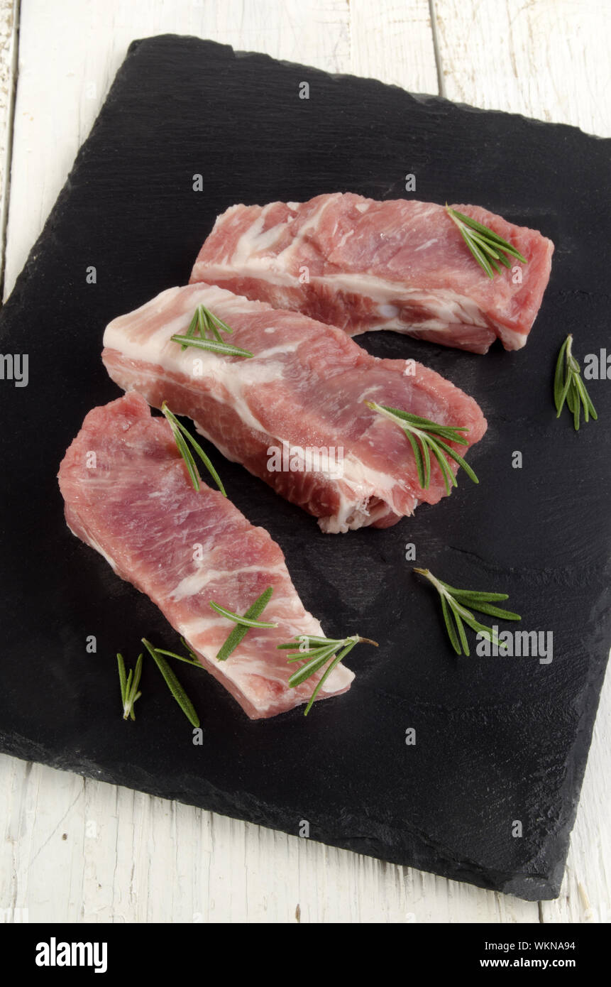 raw ribs with rosemary on slate plate Stock Photo - Alamy