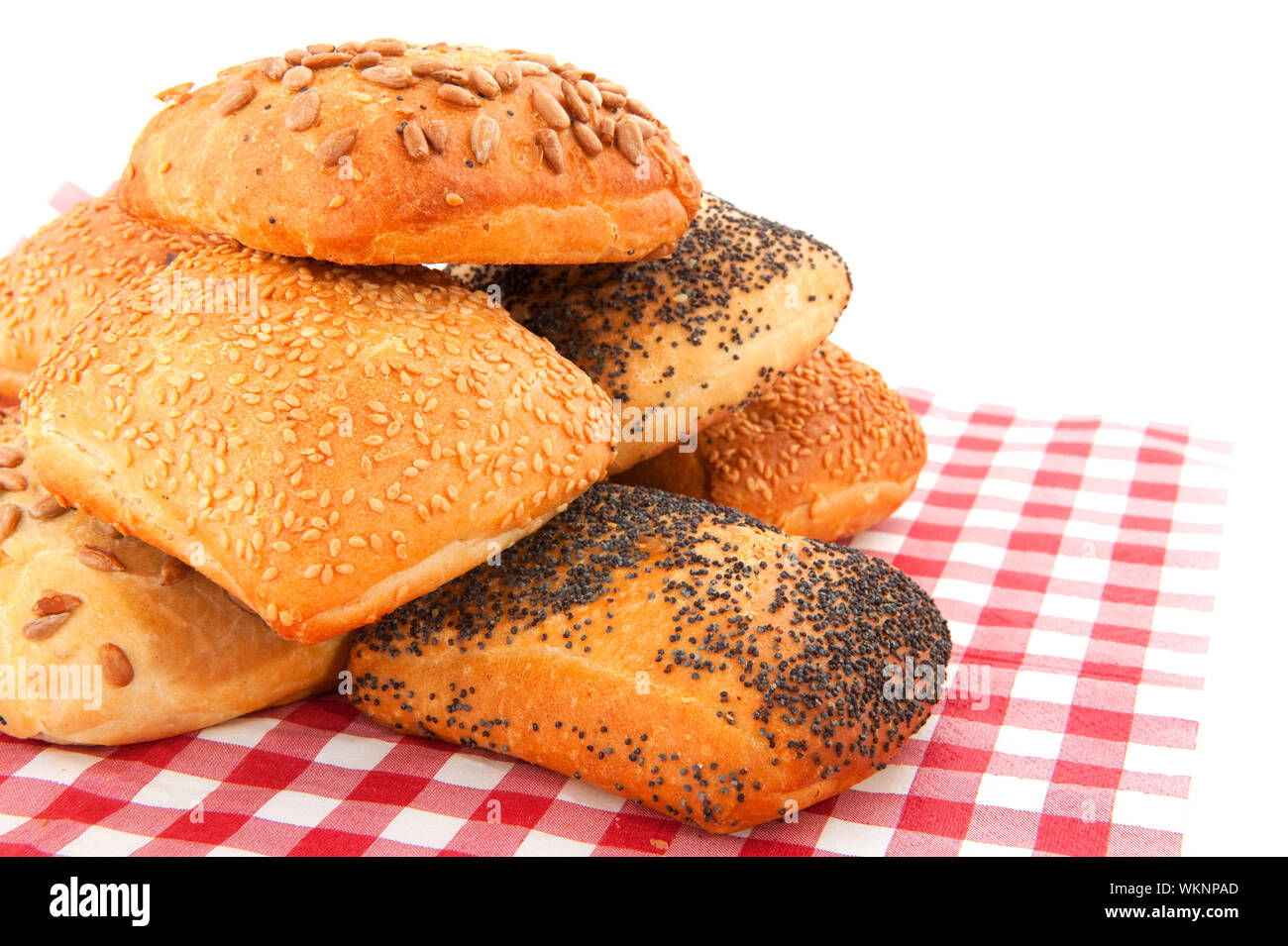 Luxury bread rolls with grain on checked napkin isolated over white ...