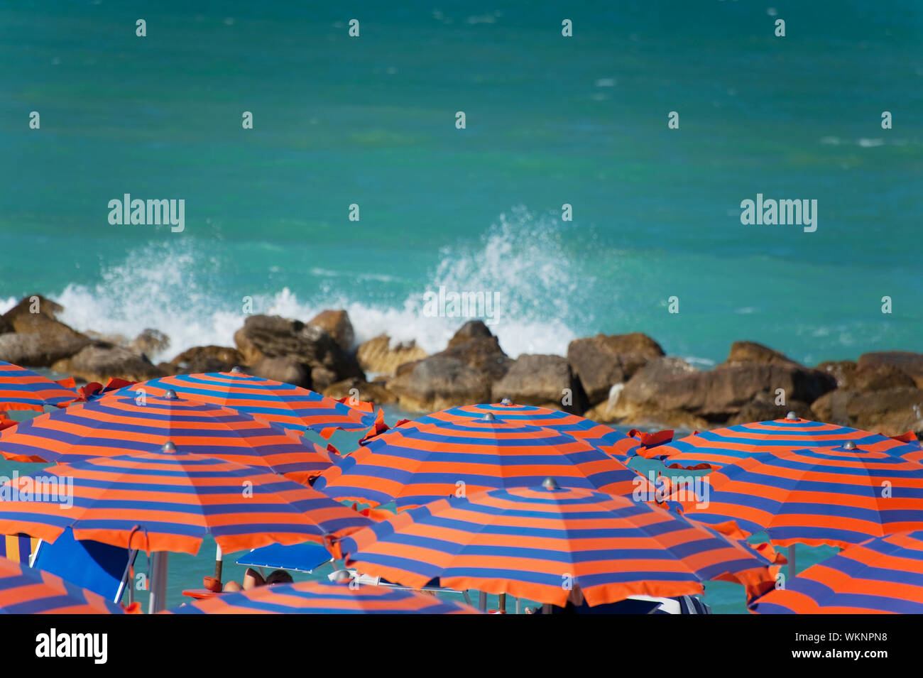 striped parasols at the beach in Italy Stock Photo - Alamy