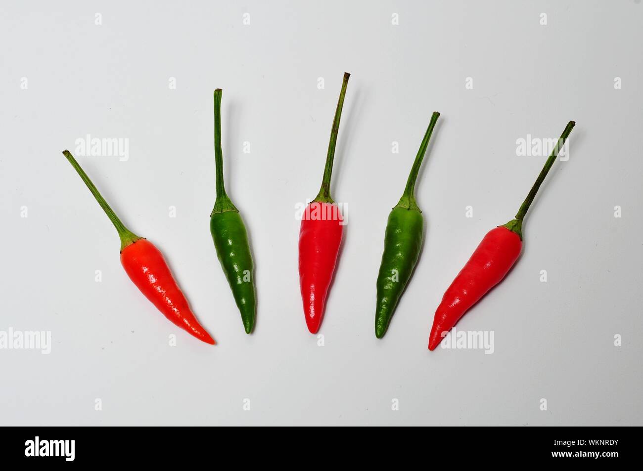 Multi Colored Chili Peppers Against White Background Stock Photo - Alamy
