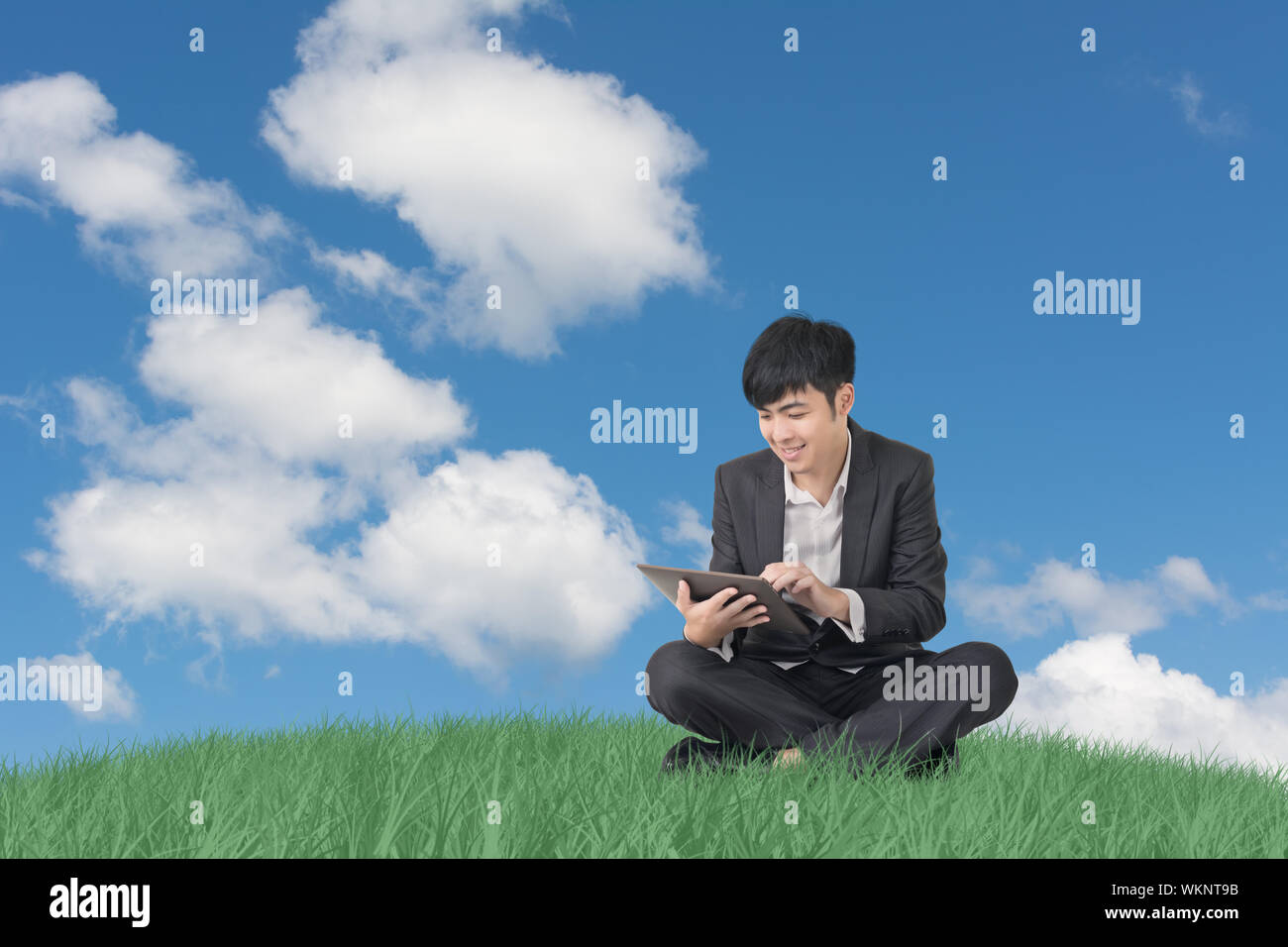 Asian businessman sit and using pad in outdoor Stock Photo - Alamy