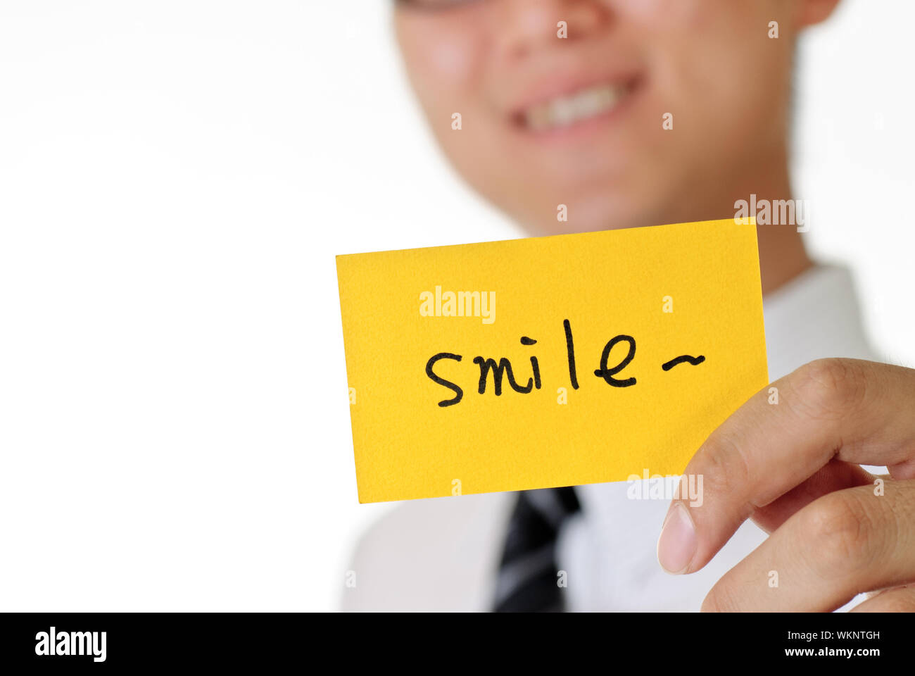 Smile, words on yellow card holding by young man Stock Photo - Alamy