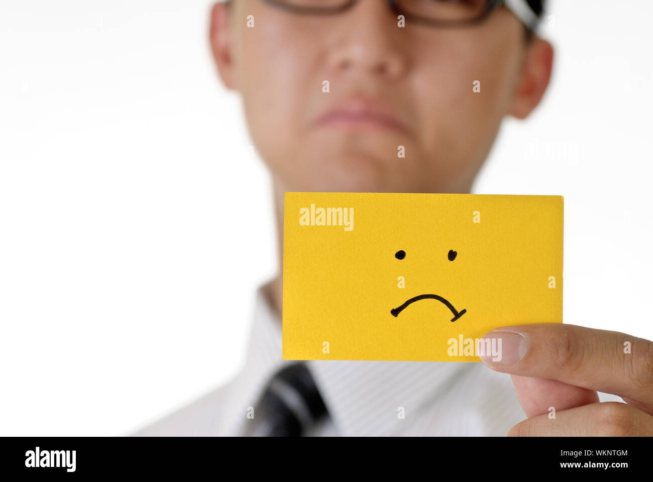Worried sign on yellow card holding by worried young man Stock Photo ...