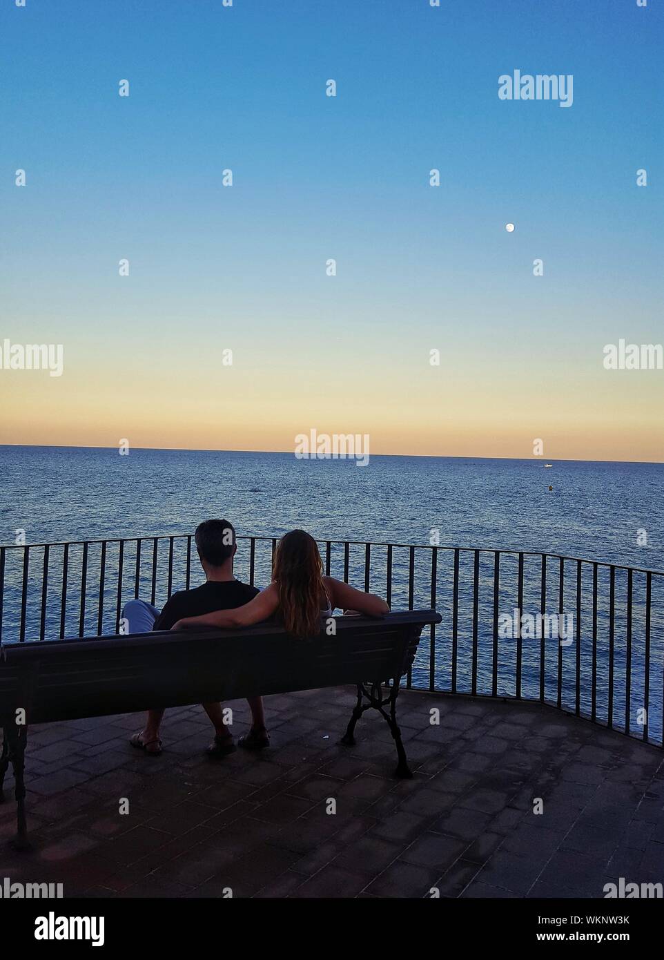 Couple sitting on bench at sunset hi-res stock photography and images ...