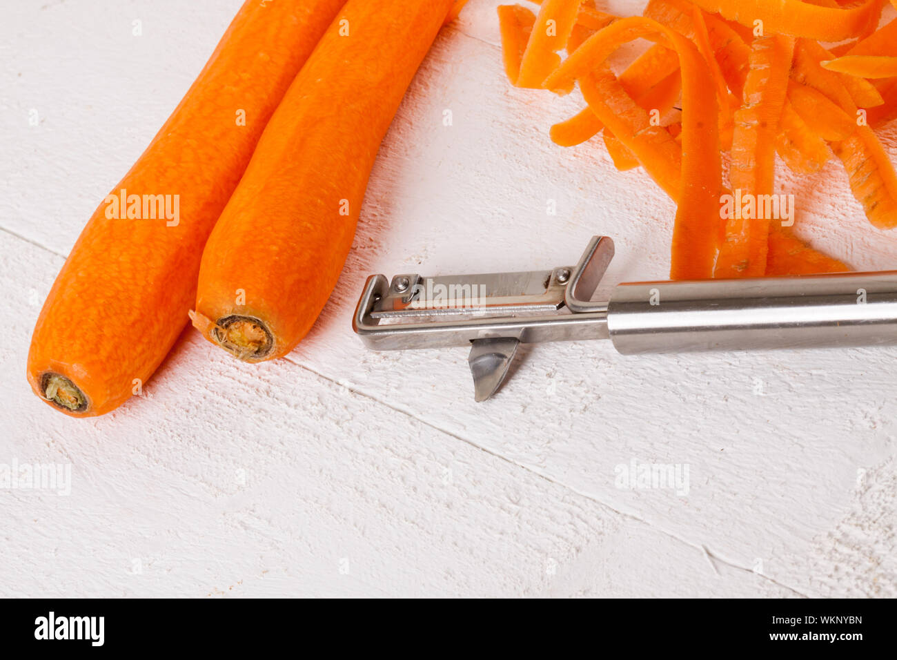 Fresh peeled carrots sliced into thin batons for carrot julienne with a ...