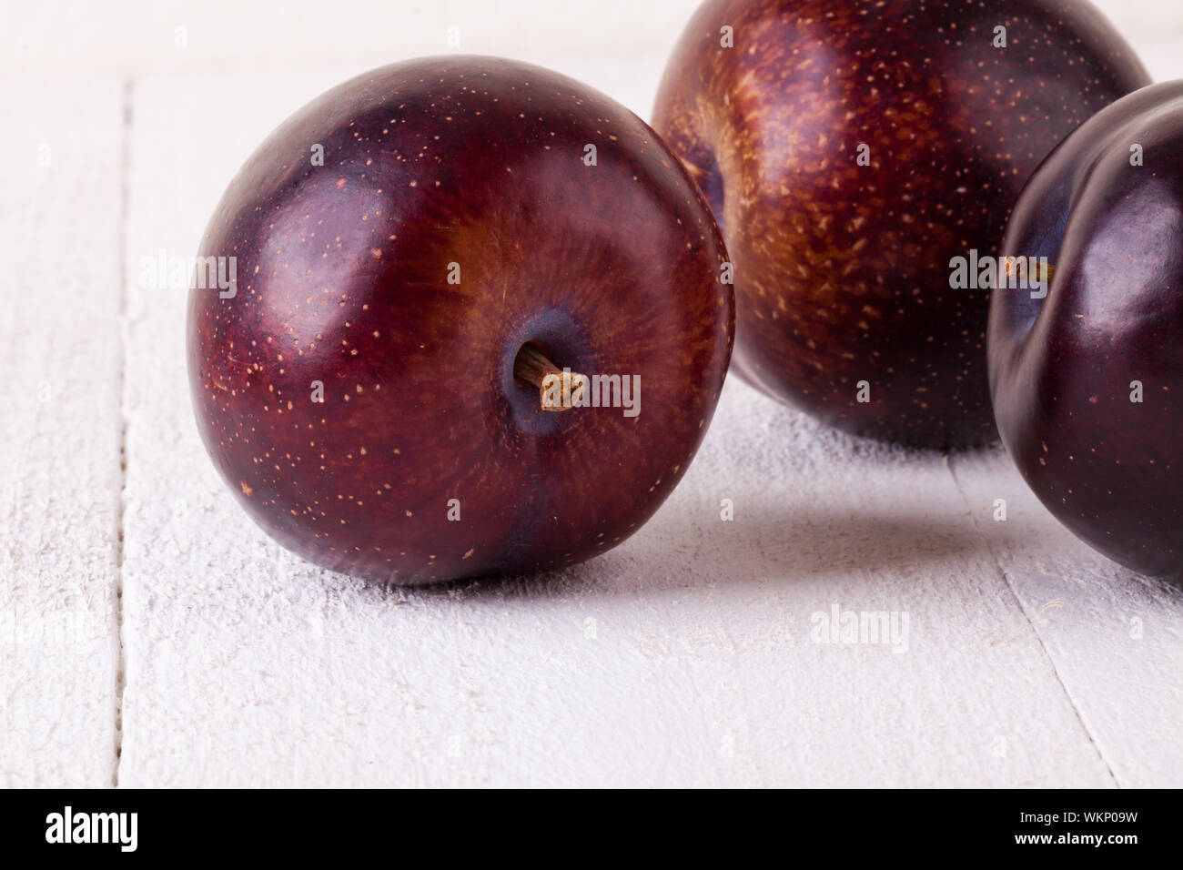 Fresh ripe red juicy appetizing plum close up view with the stalk ...