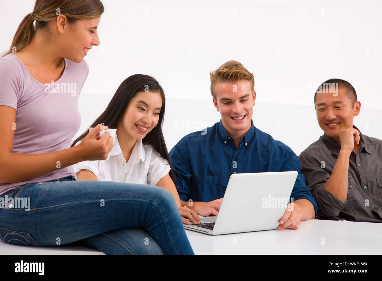 Group of happy friends using laptop Stock Photo - Alamy