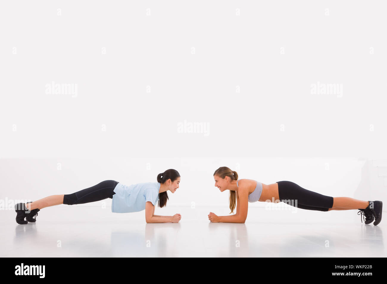 Two young woman doing push-ups in gym Stock Photo - Alamy