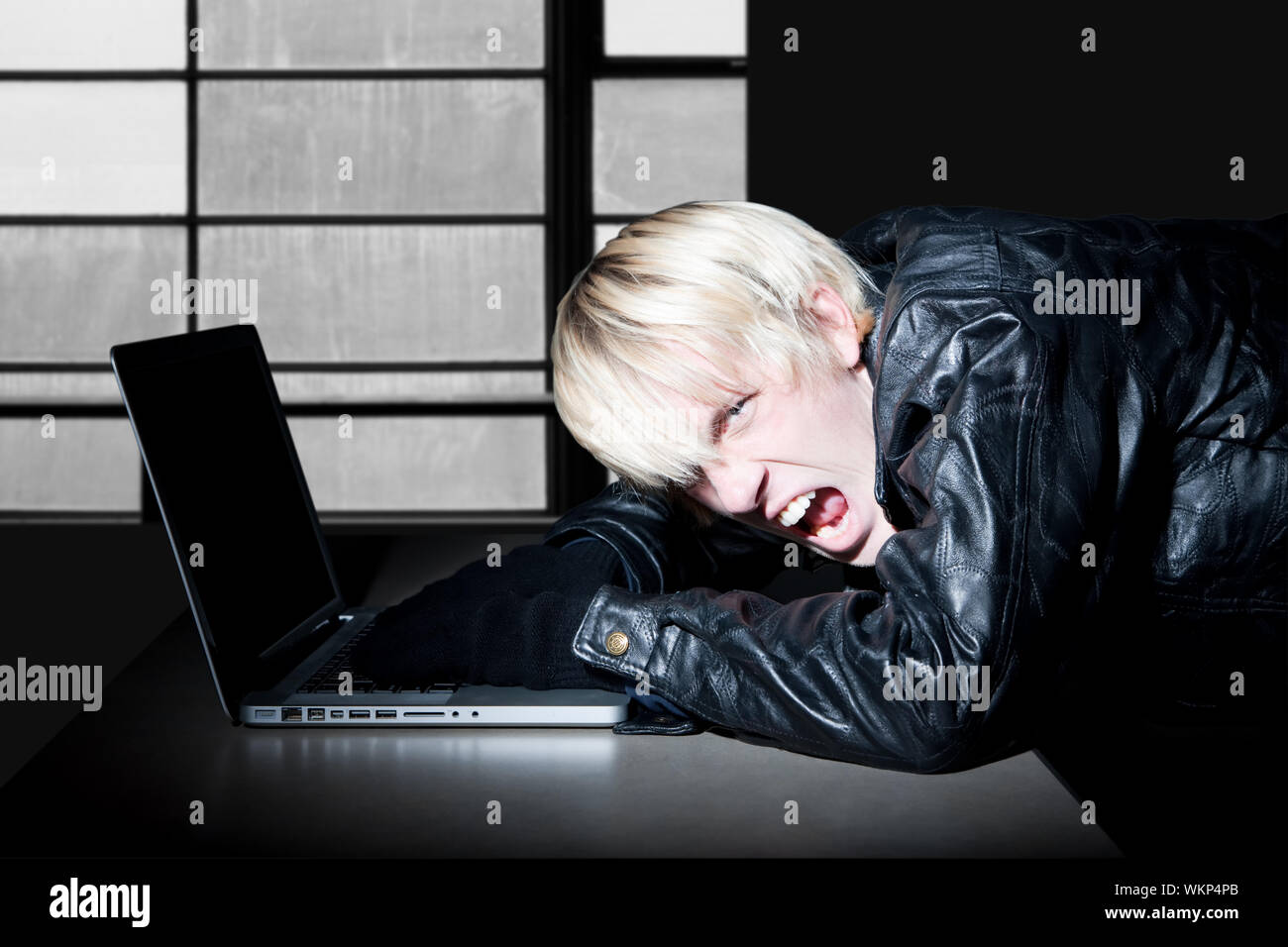 Computer criminal hacking on a laptop in secret location Stock Photo ...